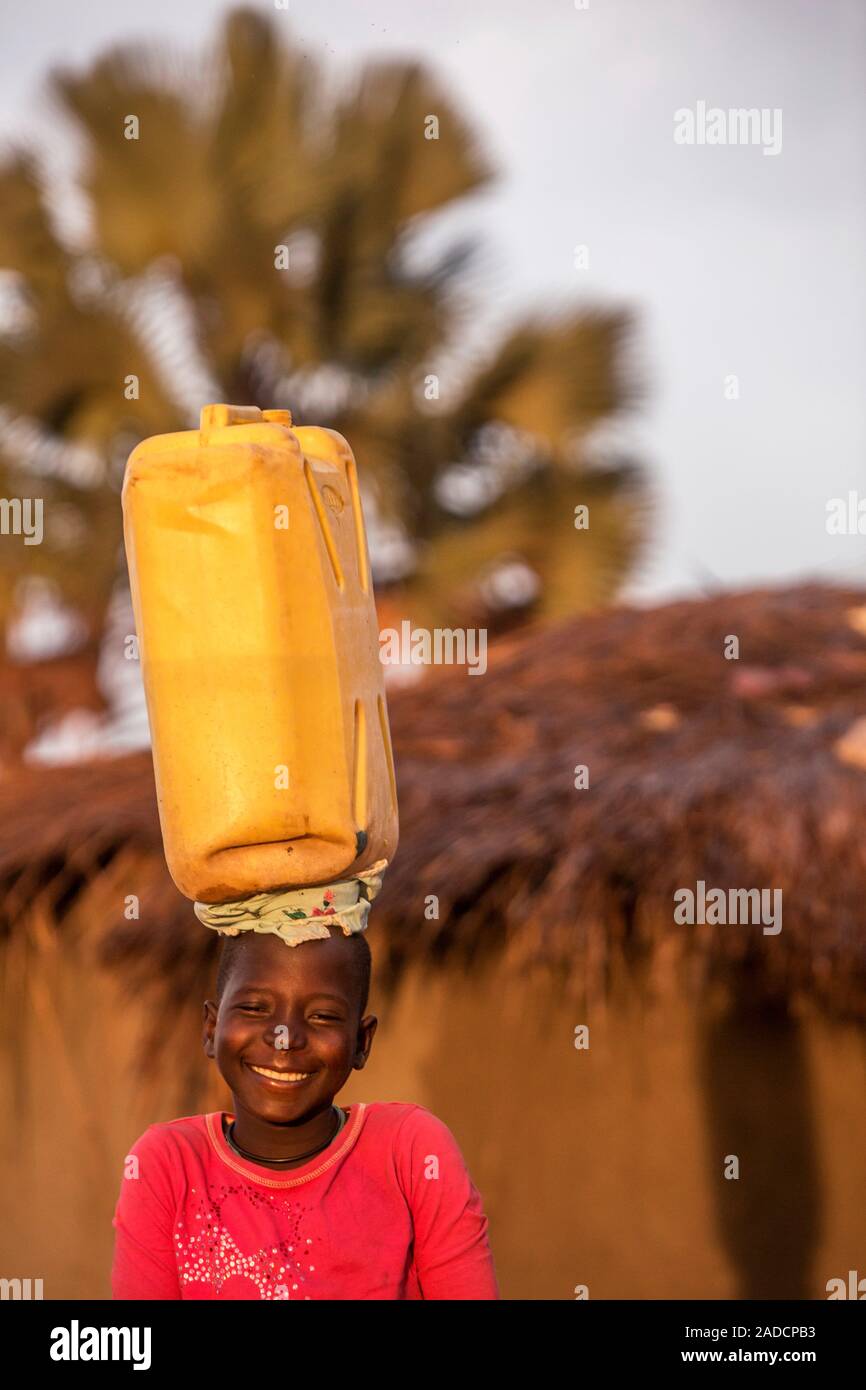 Head carrying in Uganda. Girl carrying a load of water on her head ...