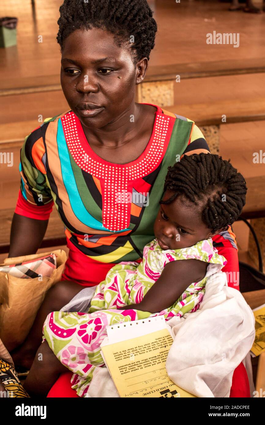 Child health check. Mother and daughter waiting to see a doctor as part ...