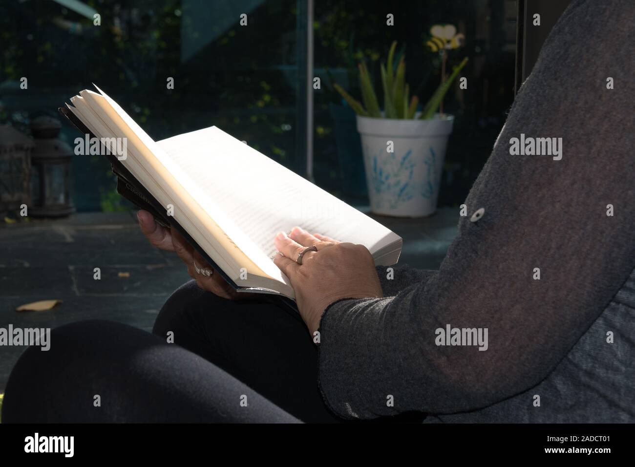 Woman reading a book at the window hi-res stock photography and images ...