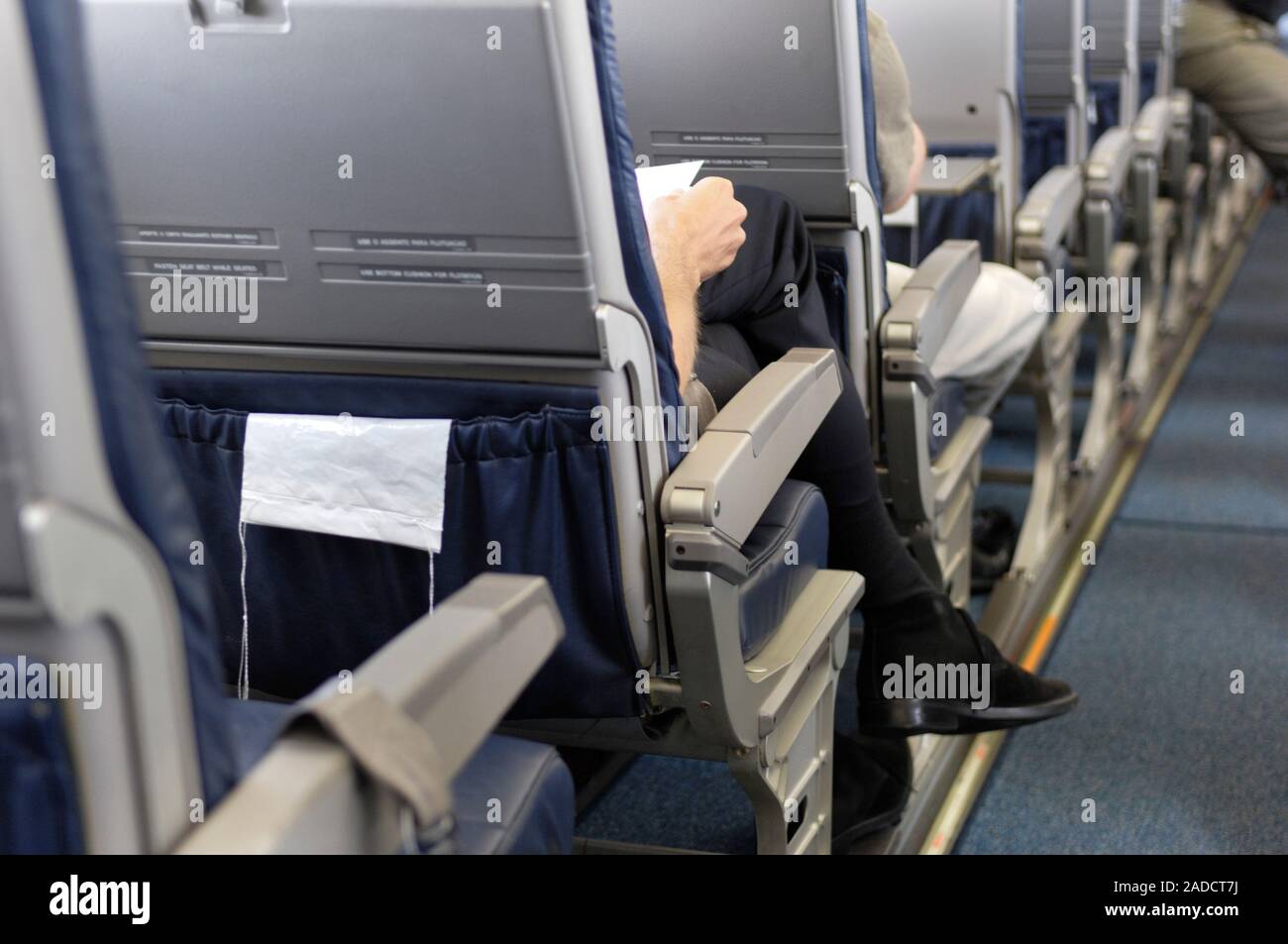 Passengers sitting in the economy class cabin seats of Embraer ERJ ...