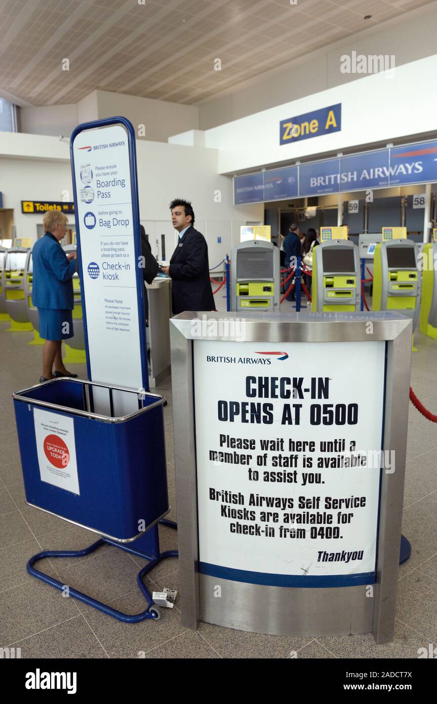 Passengers checking-in at British Airways self-service check-in kiosks ...
