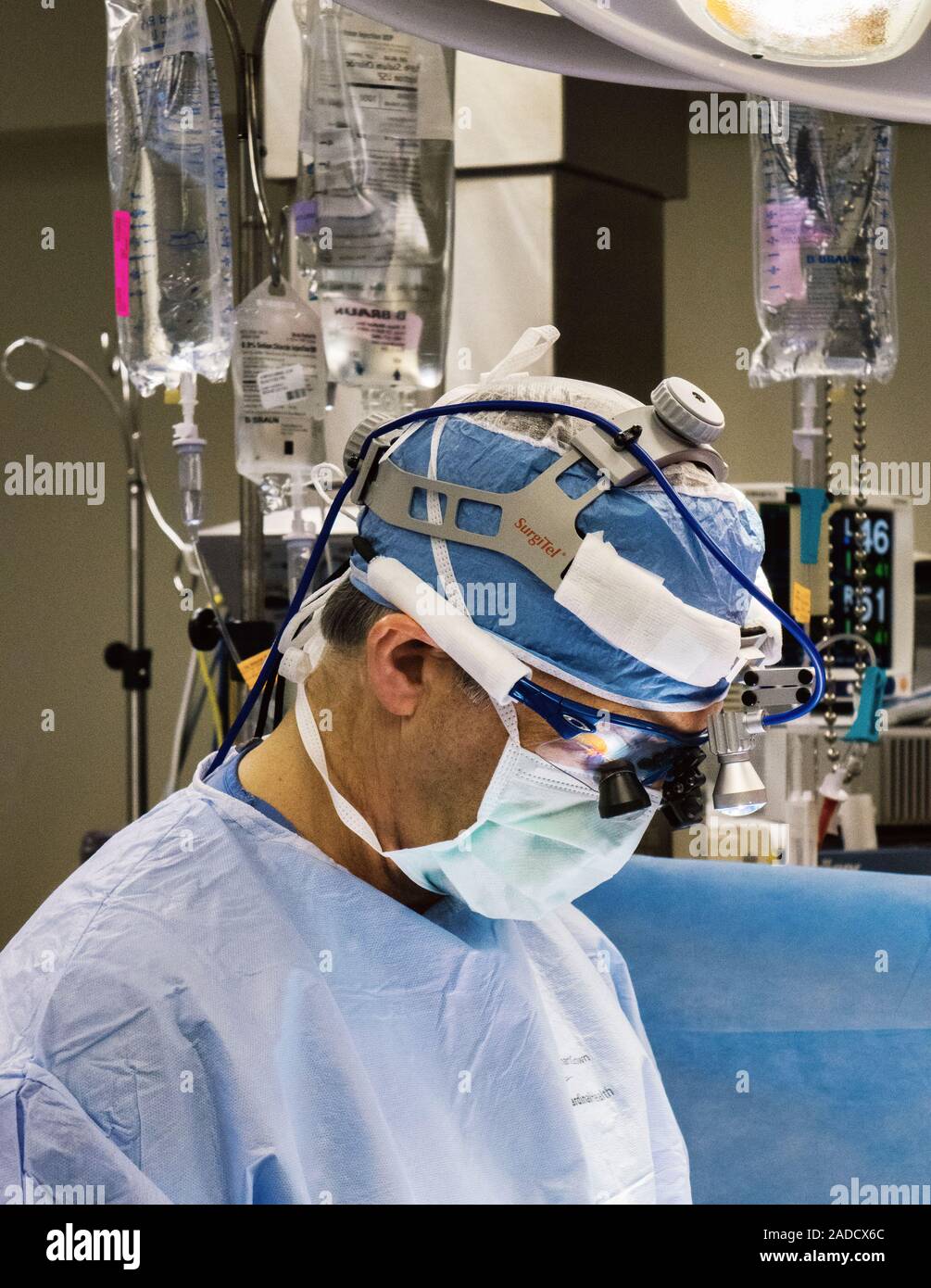 Cardiac surgeon. Heart surgeon wearing headlamp and loupes. The loupes ...