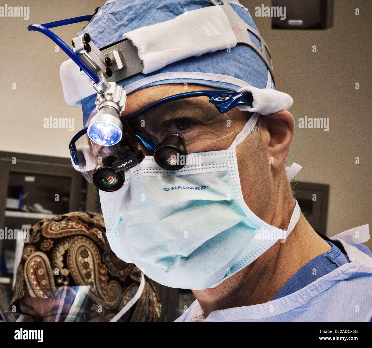 Cardiac surgeon. Heart surgeon wearing headlamp and loupes. The loupes ...