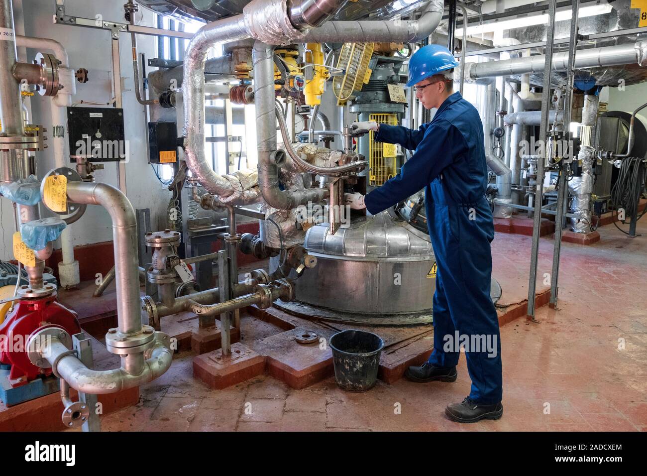 CalaChem chemical factory. Worker collecting a chemical sample from a ...