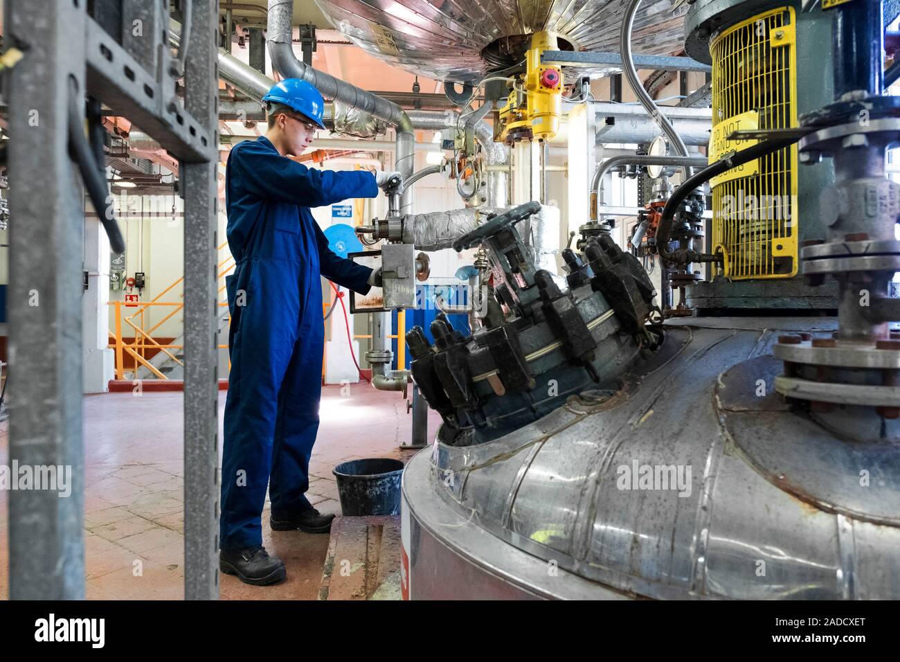 CalaChem chemical factory. Worker collecting a chemical sample from a ...