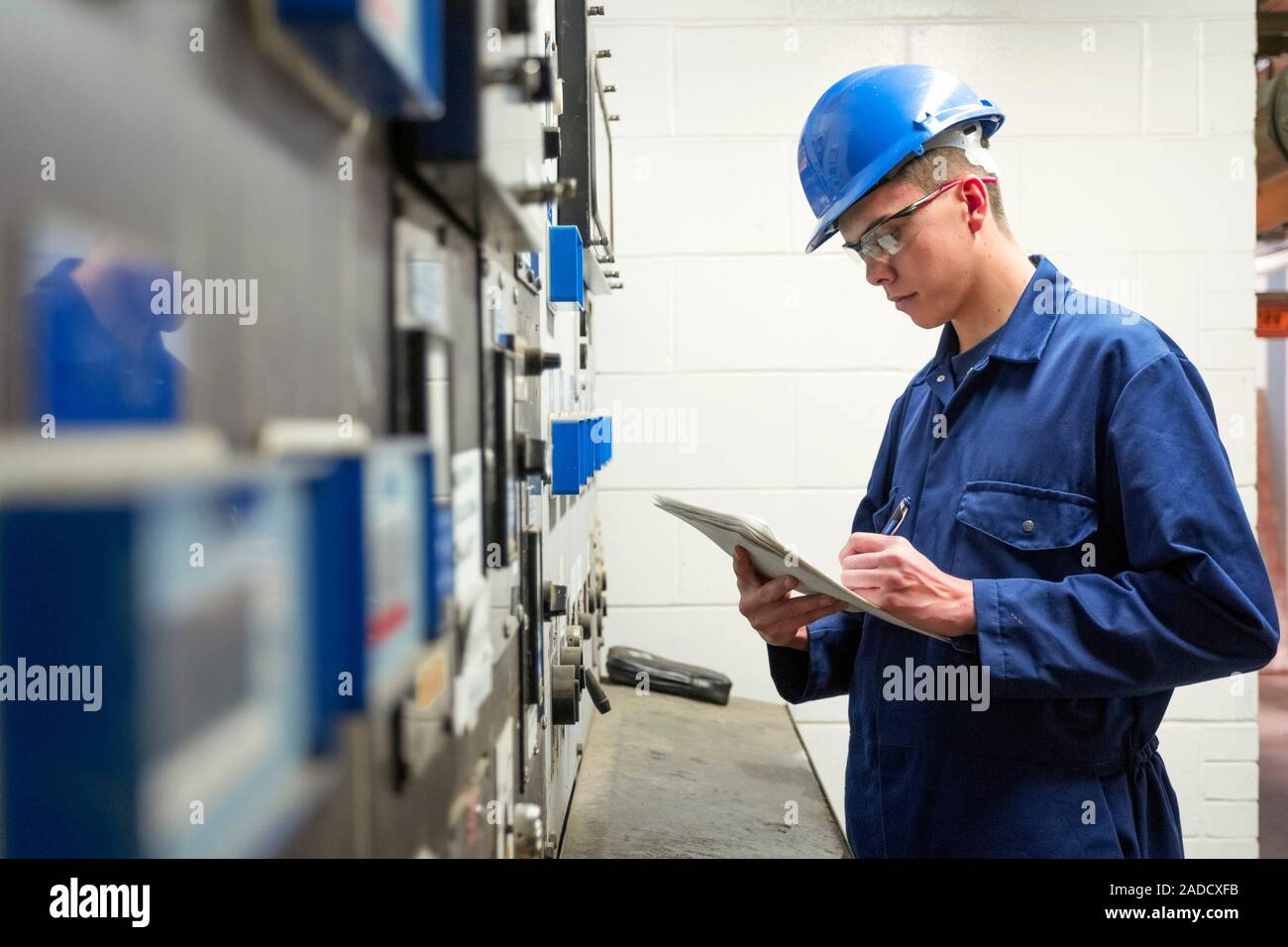 CalaChem chemical factory. Worker taking pressure and level readings in ...