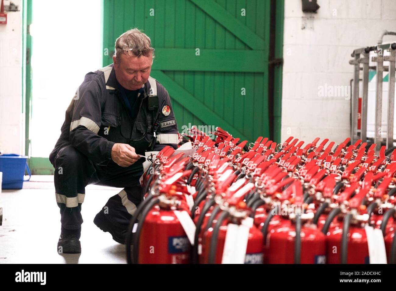 CalaChem chemical factory. Worker checking new fire extinguishers ready ...