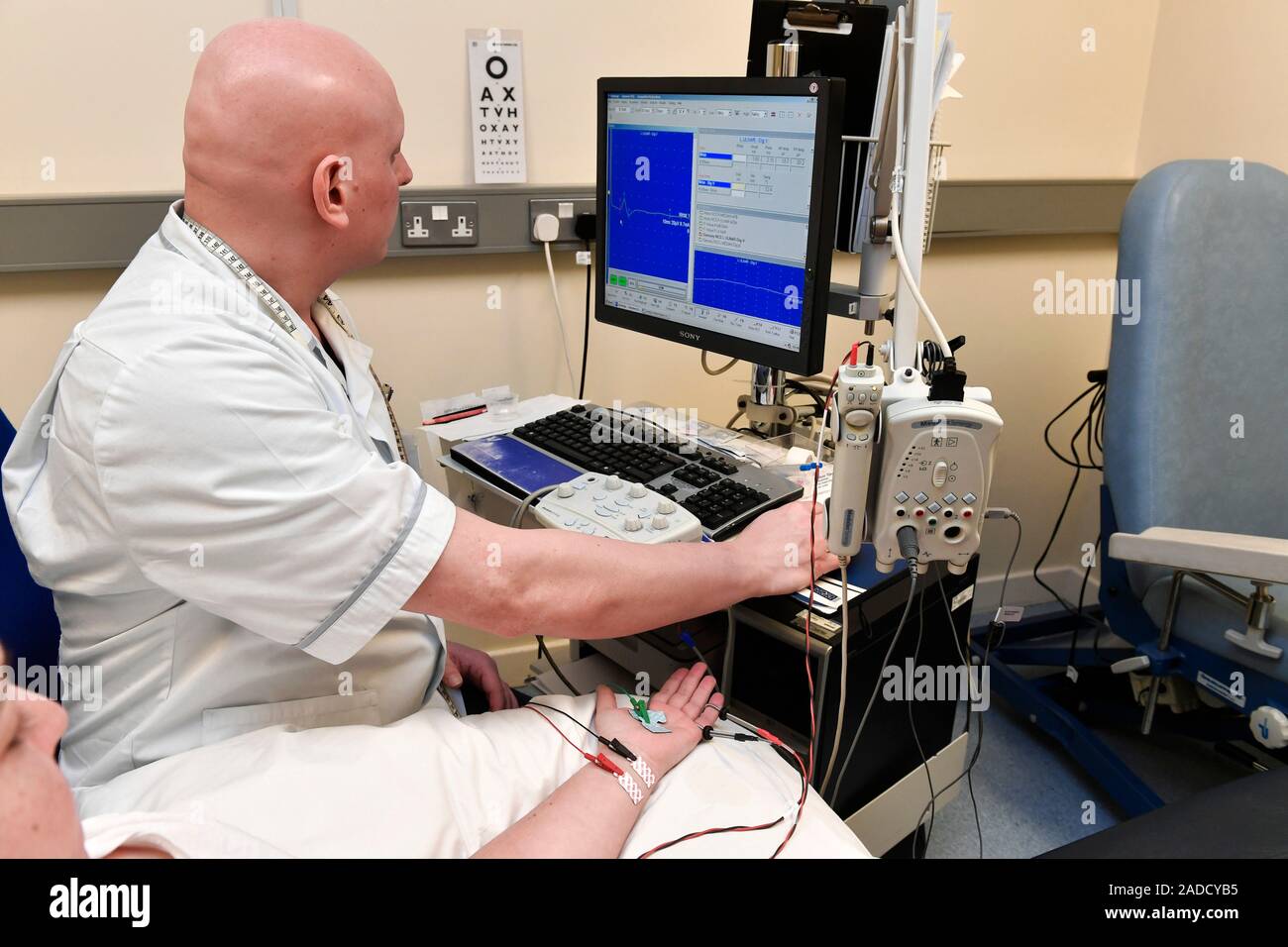 Nerve conduction test on wrist patient. Medical specialist carrying out ...