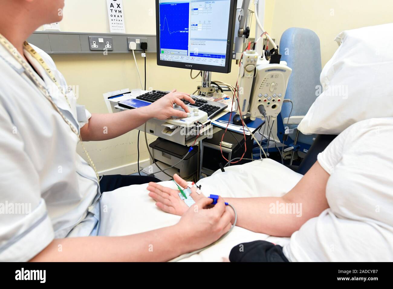 Nerve conduction test on wrist patient. Medical specialist carrying out ...