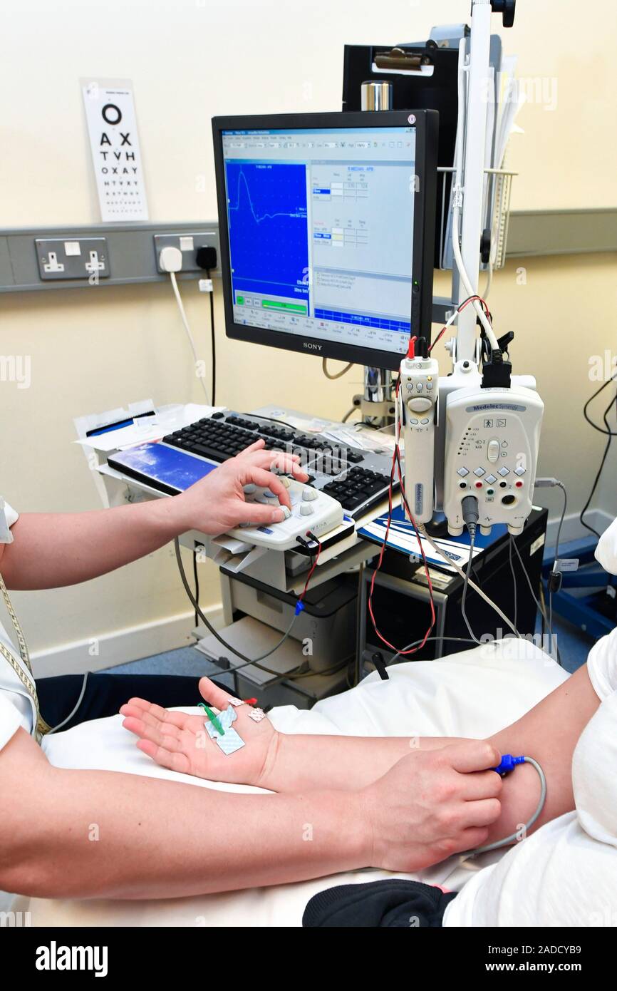 Nerve conduction test on wrist patient. Medical specialist carrying out ...