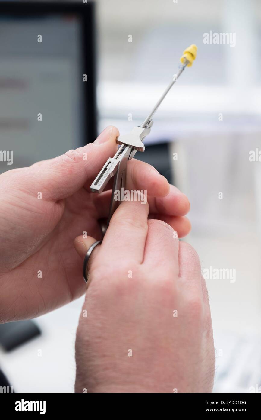 Hearing aid fitting. Doctor preparing a Phonak Lyric inner ear hearing ...