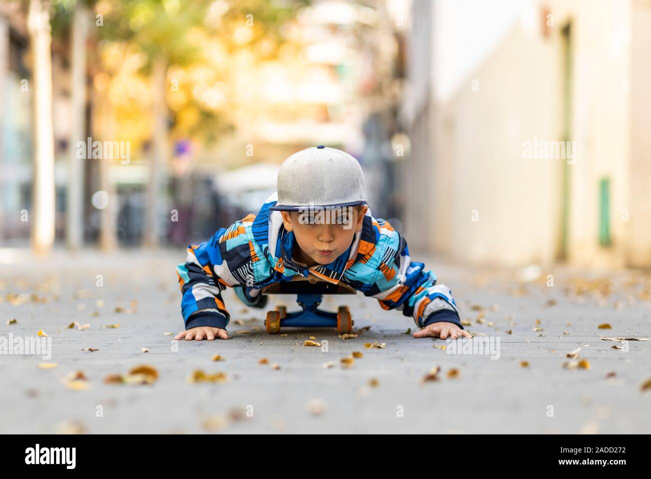 Cute little kid stretched on a skateboard Stock Photo - Alamy