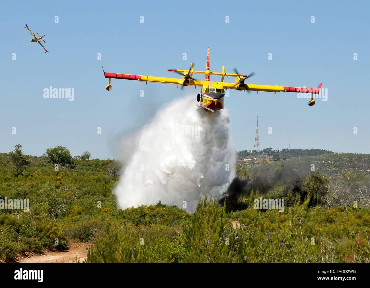 Firefighting aircraft dropping fire retardant on a fire during a ...