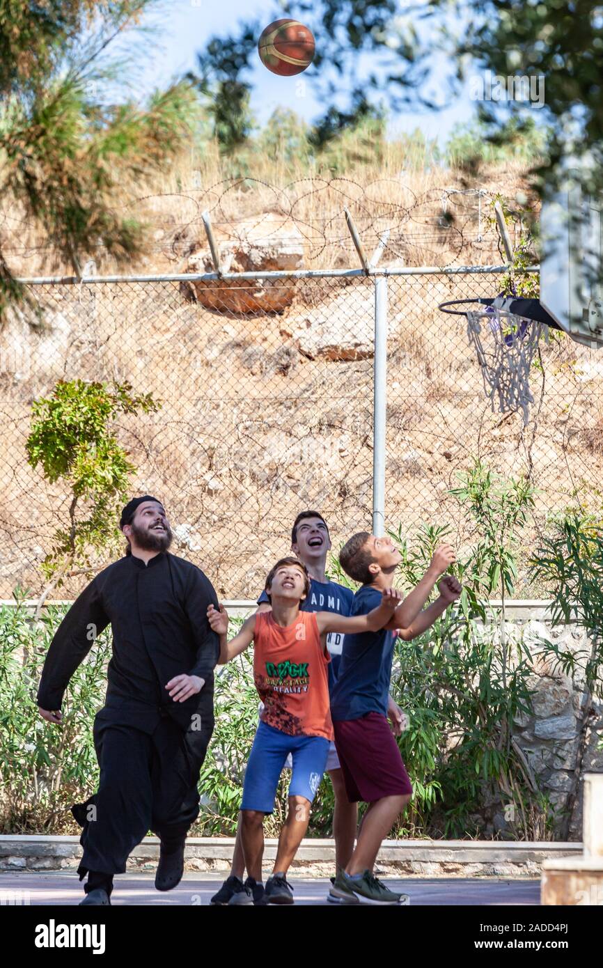 Greek orthodox priest playing basket with children Stock Photo - Alamy