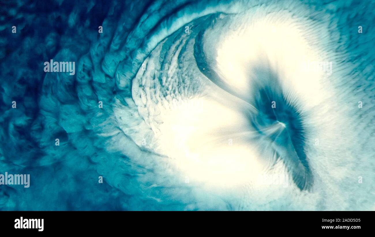 Dynamic liquid flow patterns. Light micrograph of liquids flowing and ...