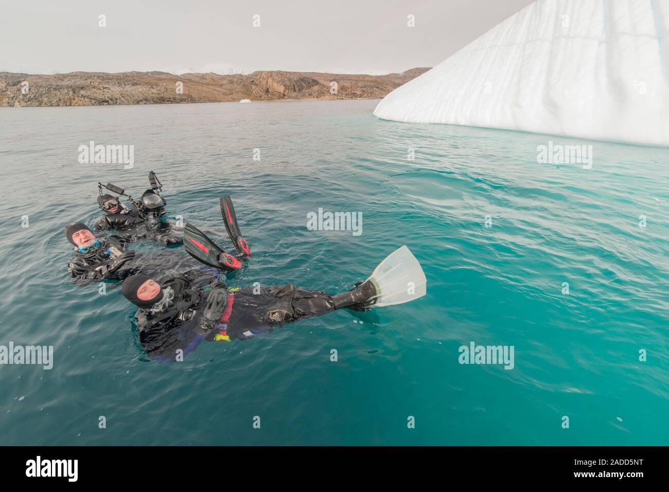 SCUBA diving next to melting iceberg near Danmark Island in a fjord in ...