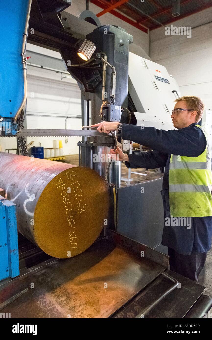 Metalworks. Worker preparing a bandsaw to cut a 1 tonne high ...