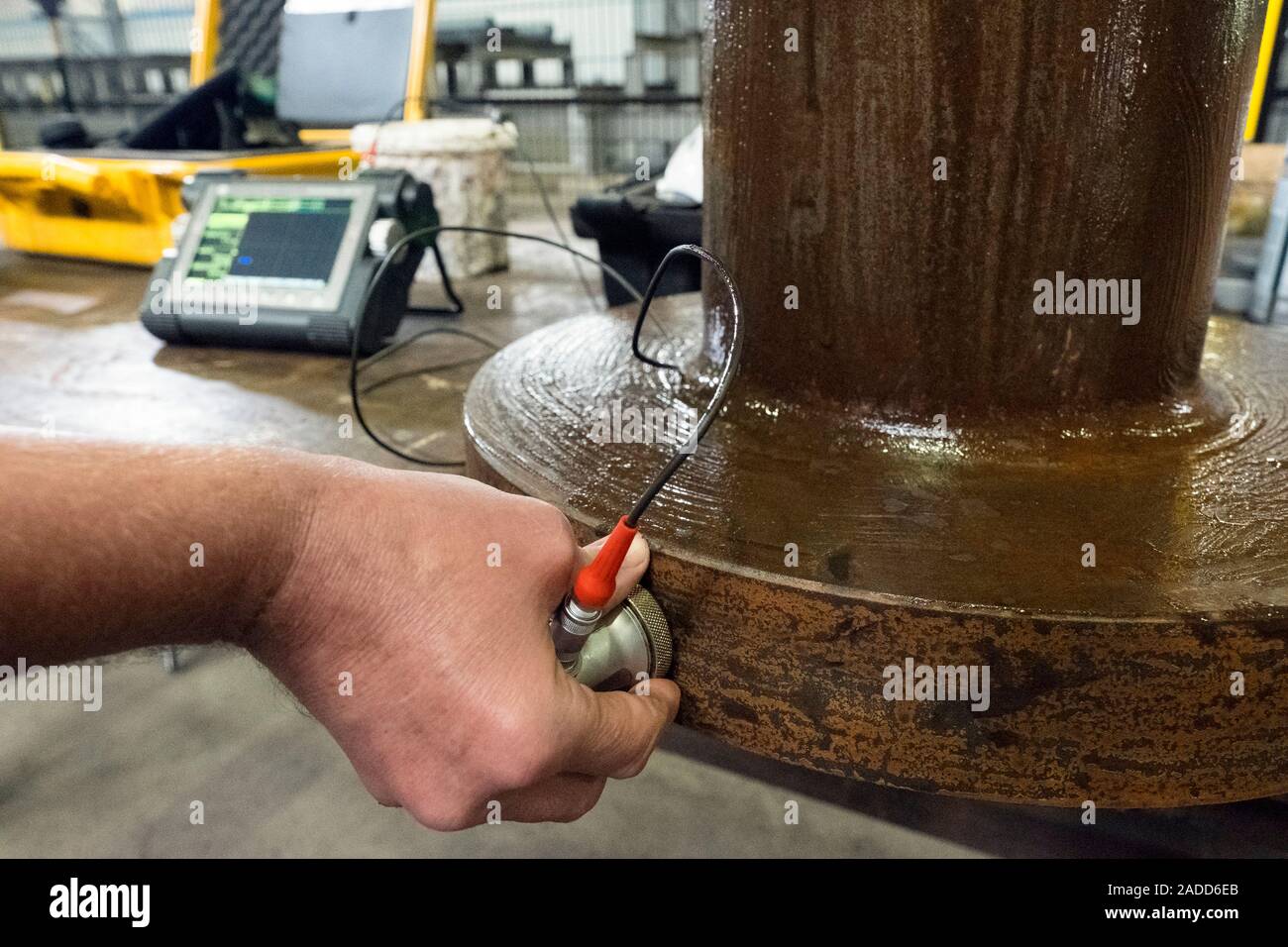 Metalworks. Worker using an ultrasonic testing machine at a metalworks ...