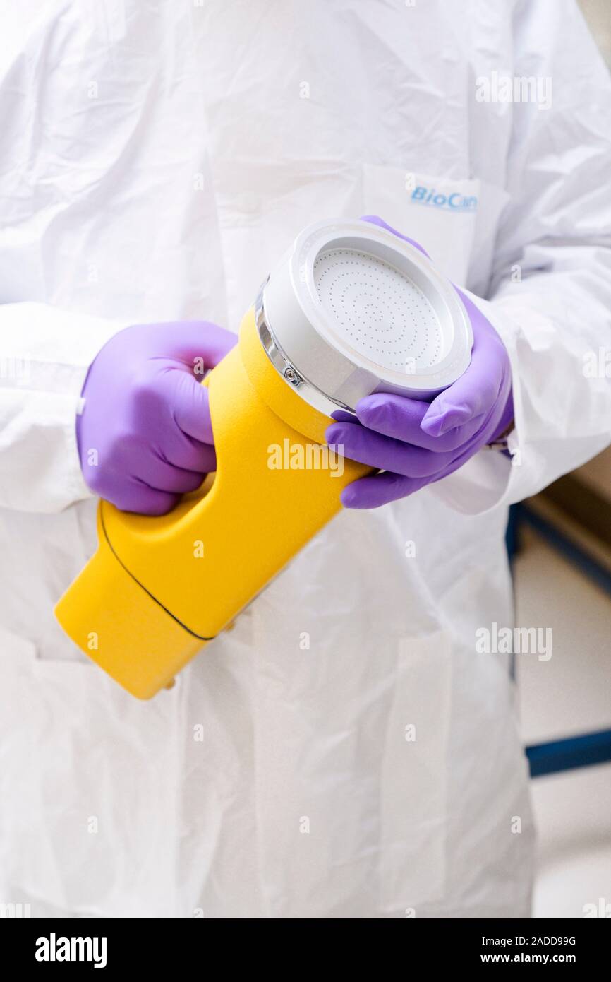 Air sampling in faecal microbiota transplant research. Researcher using ...