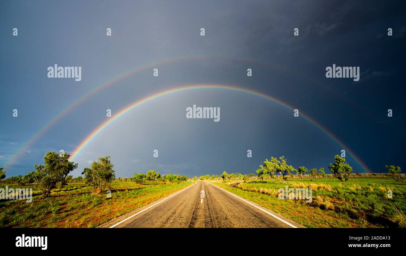 Double rainbow over a road during a storm. Photographed in Western ...