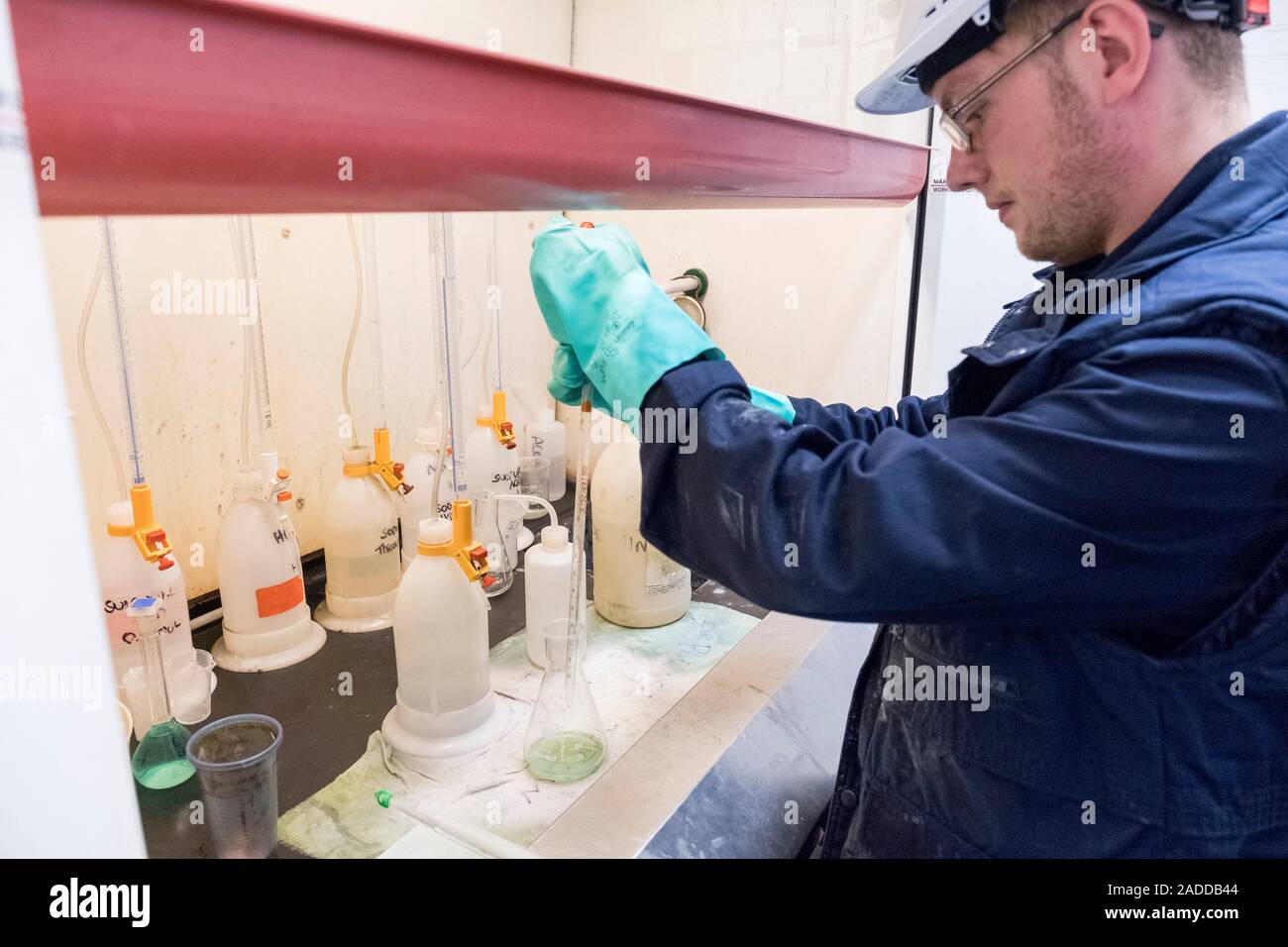 Electroless nickel plating factory. Worker testing chemical samples for ...