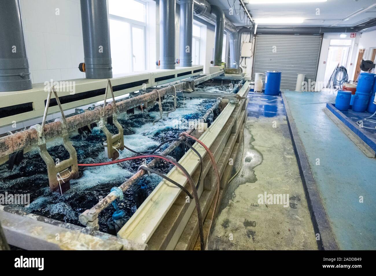 Copper plating factory. Products in chemical plating tanks at a factory ...