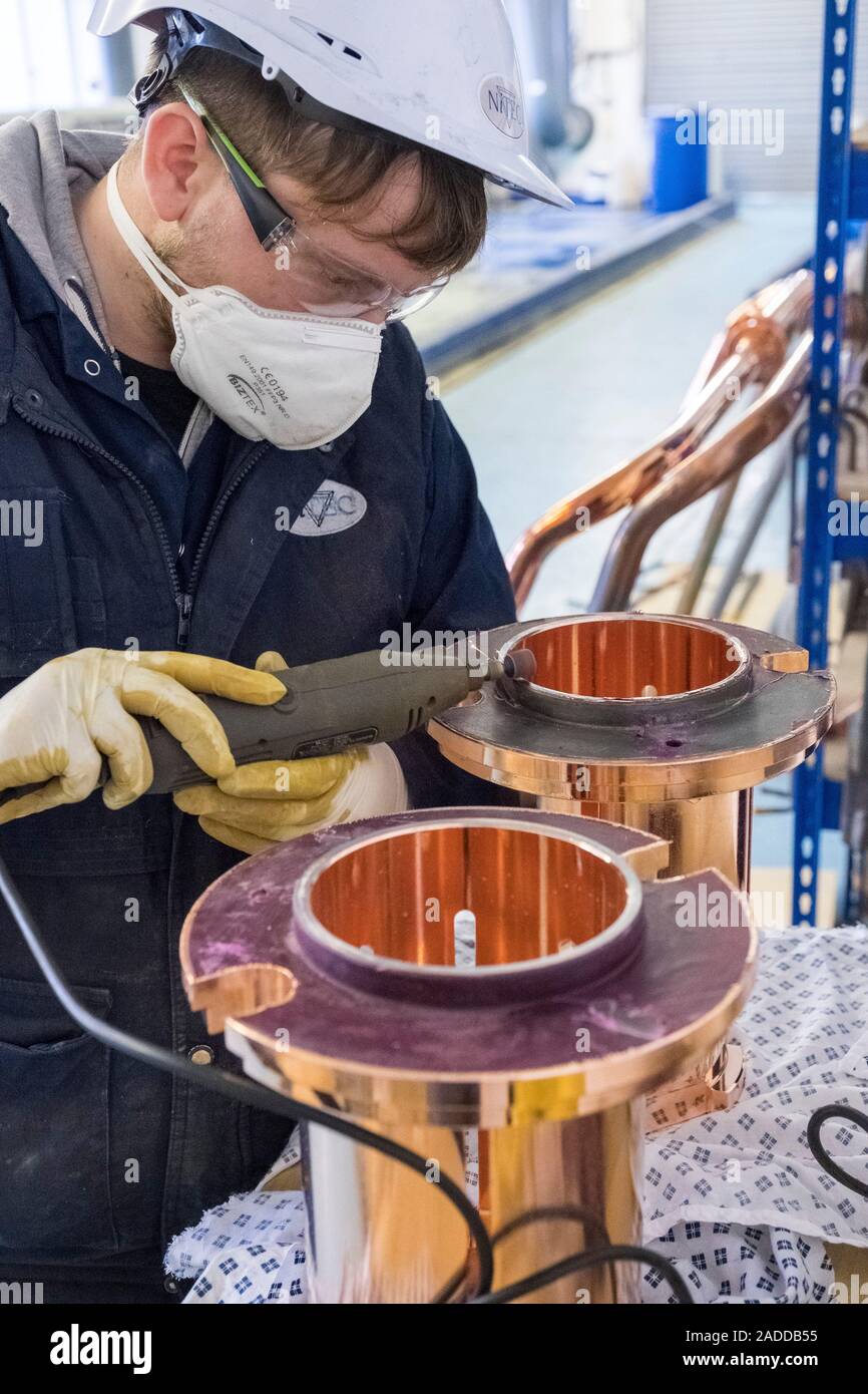 Copper plating factory. Worker finishing a copper plated product at a ...