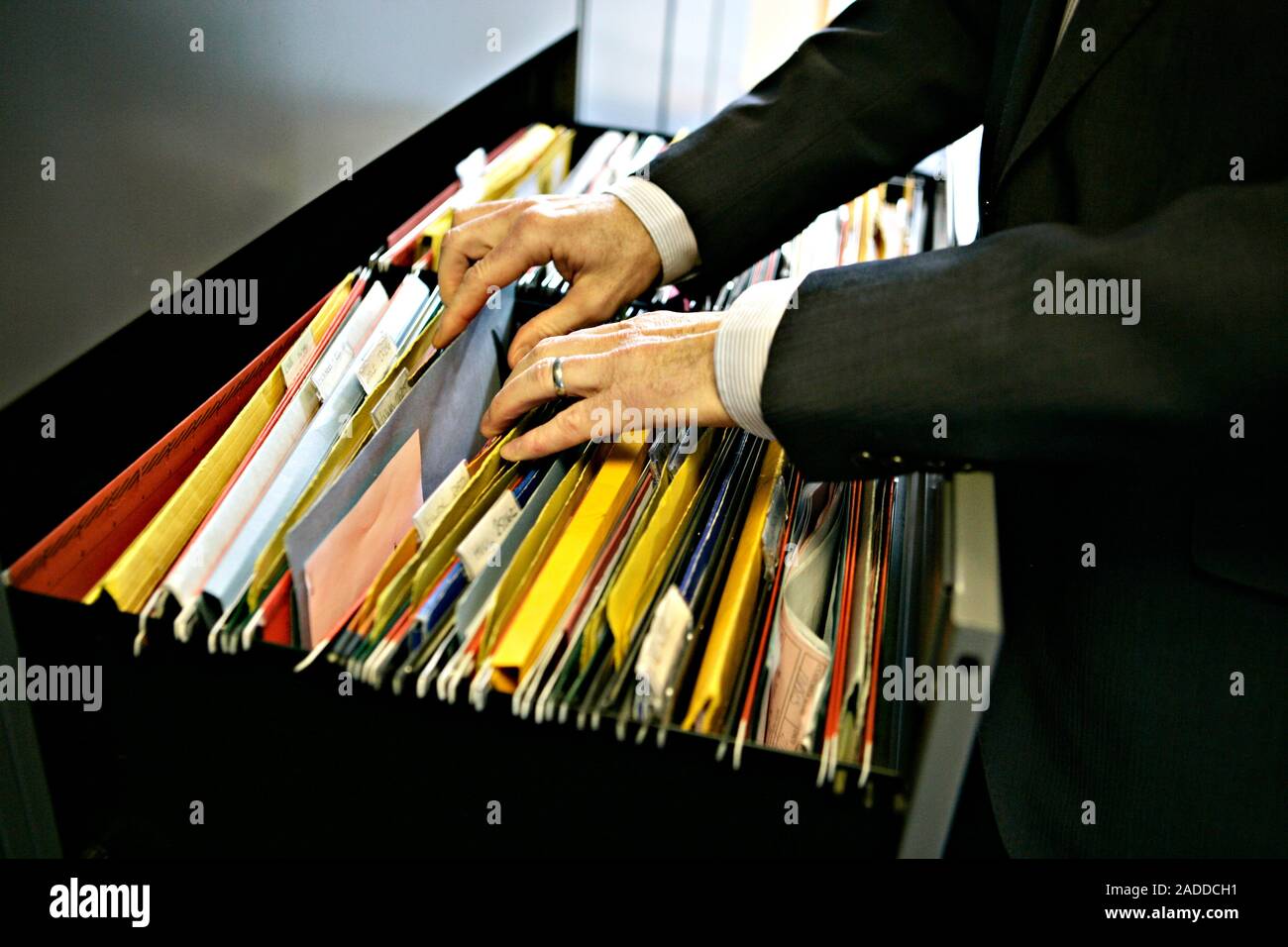 Worker looking through files in a filing cabinet Stock Photo - Alamy