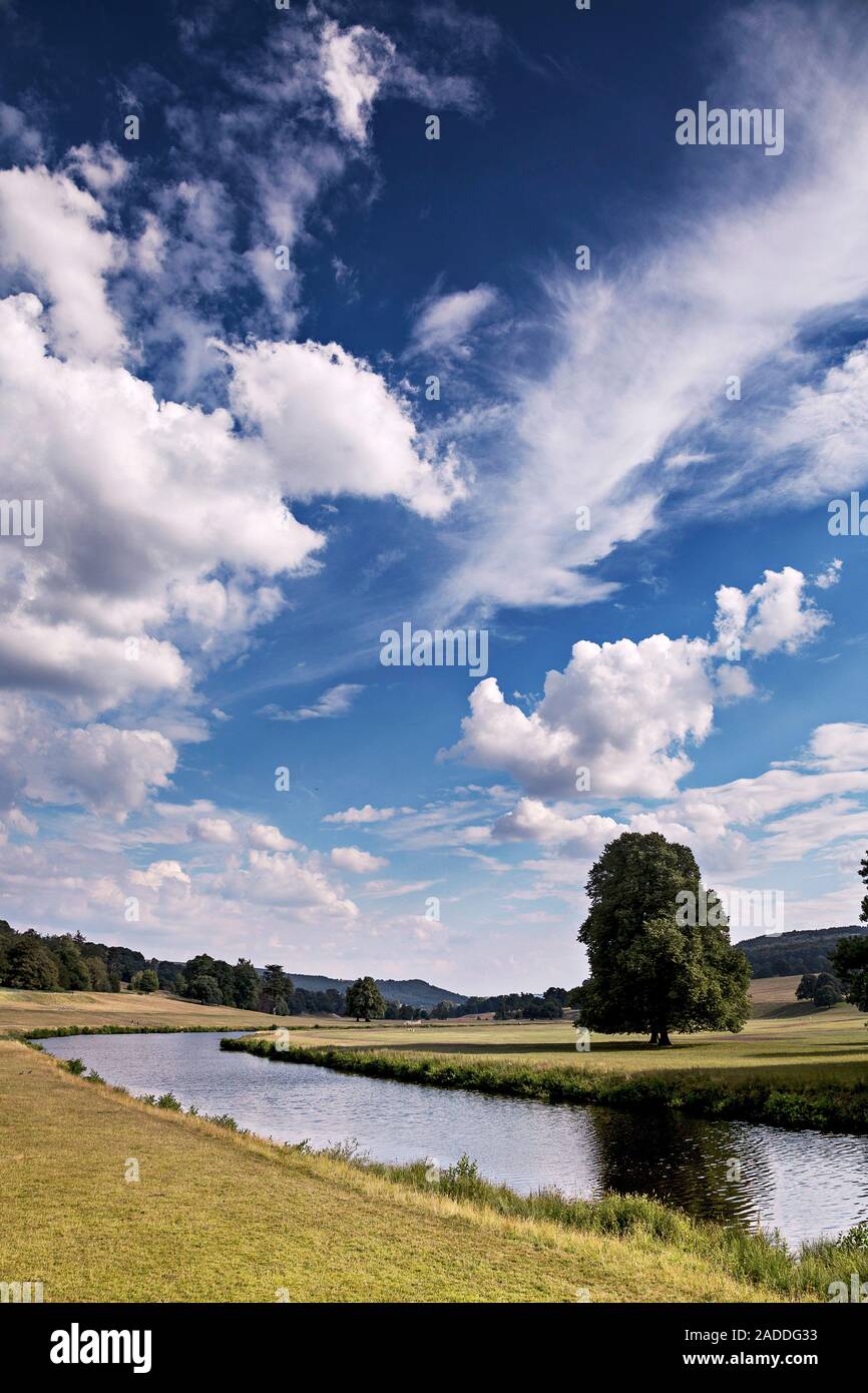 Cumulus and cirrus clouds over a river. Shallow cumulus (cumulus ...