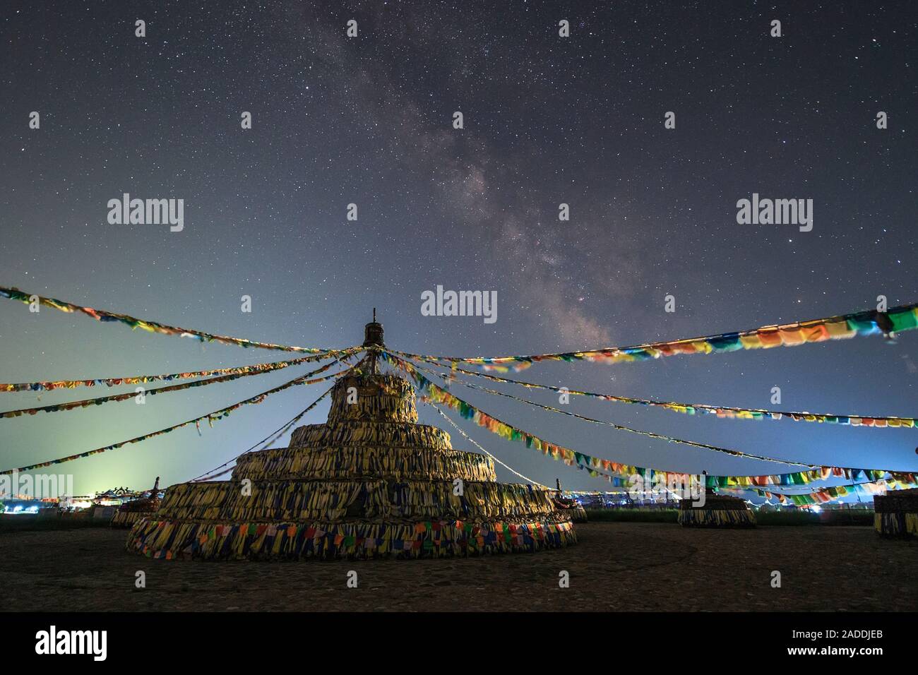 Milky Way over Mongolian ovoo. The ovoo is draped with colourful prayer ...