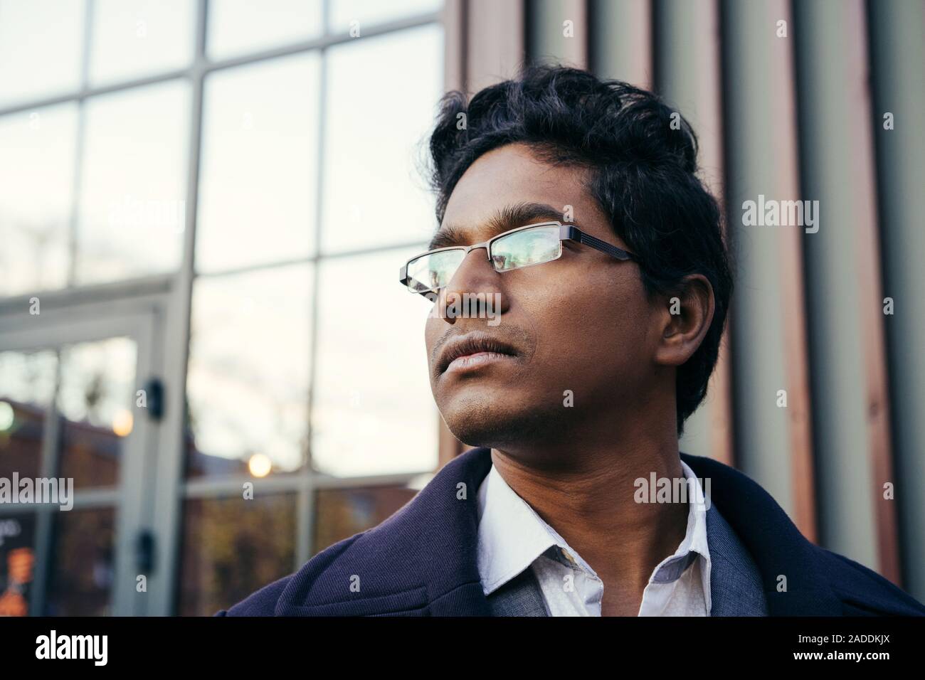 Young handsome Indian man in an office suit and white shirt, with ...