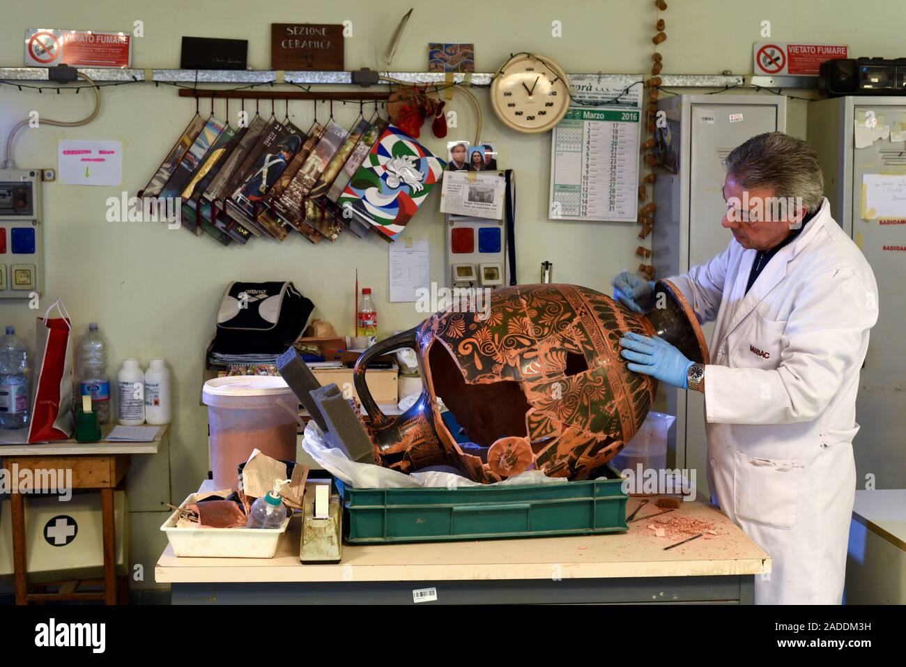 Restoration of Roman ceramic vessel. Restorer working on a Roman ...