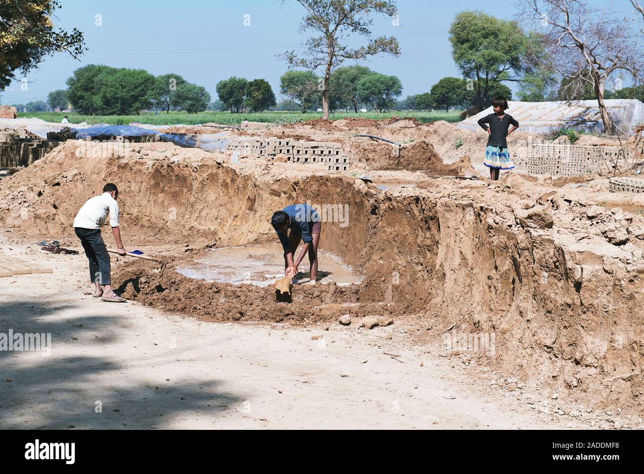 Mud brick industry. Workers preparing clay and mud that will be shaped ...