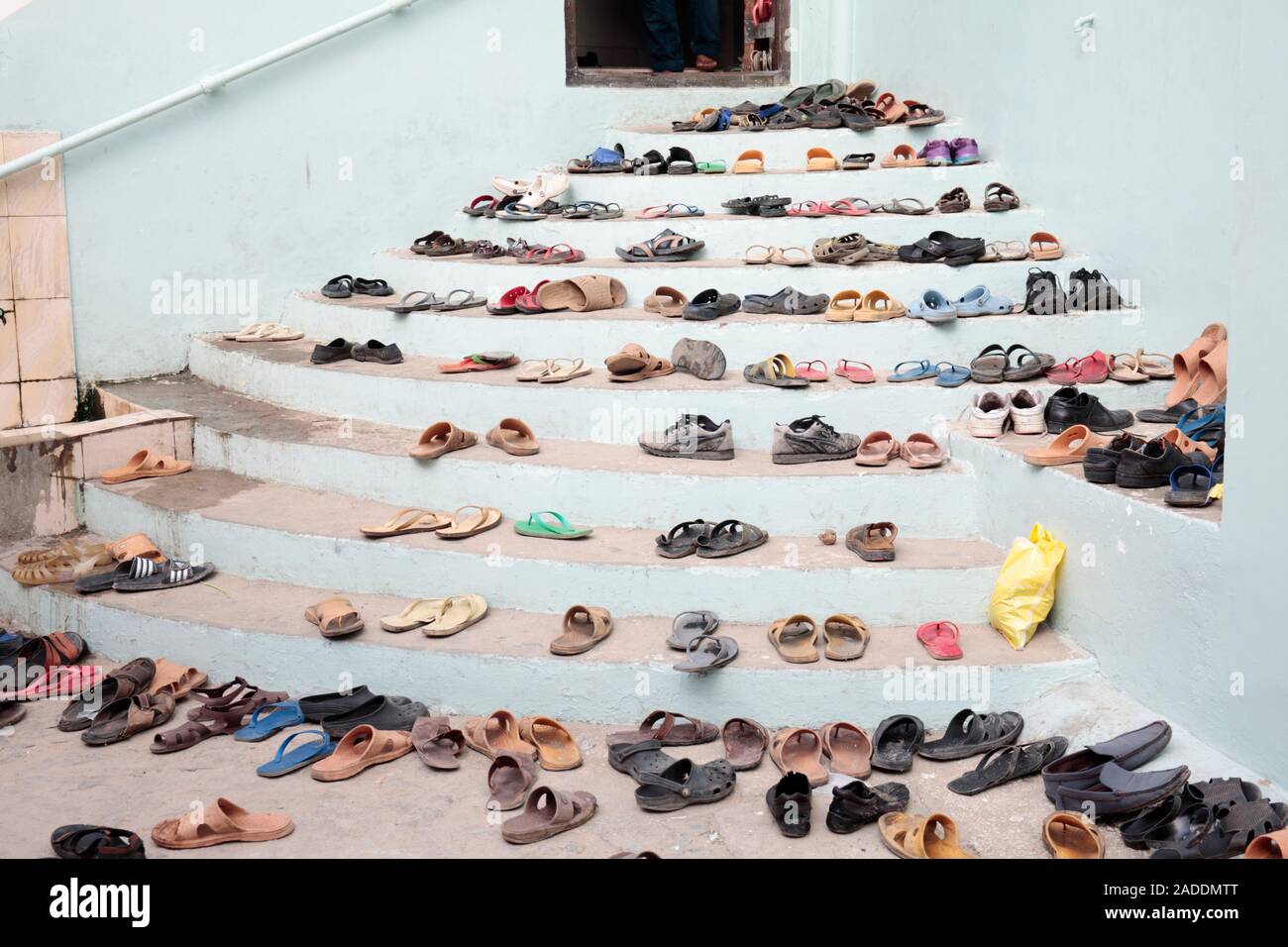 Shoes outside a mosque. Array of sandals and shoes left on steps ...