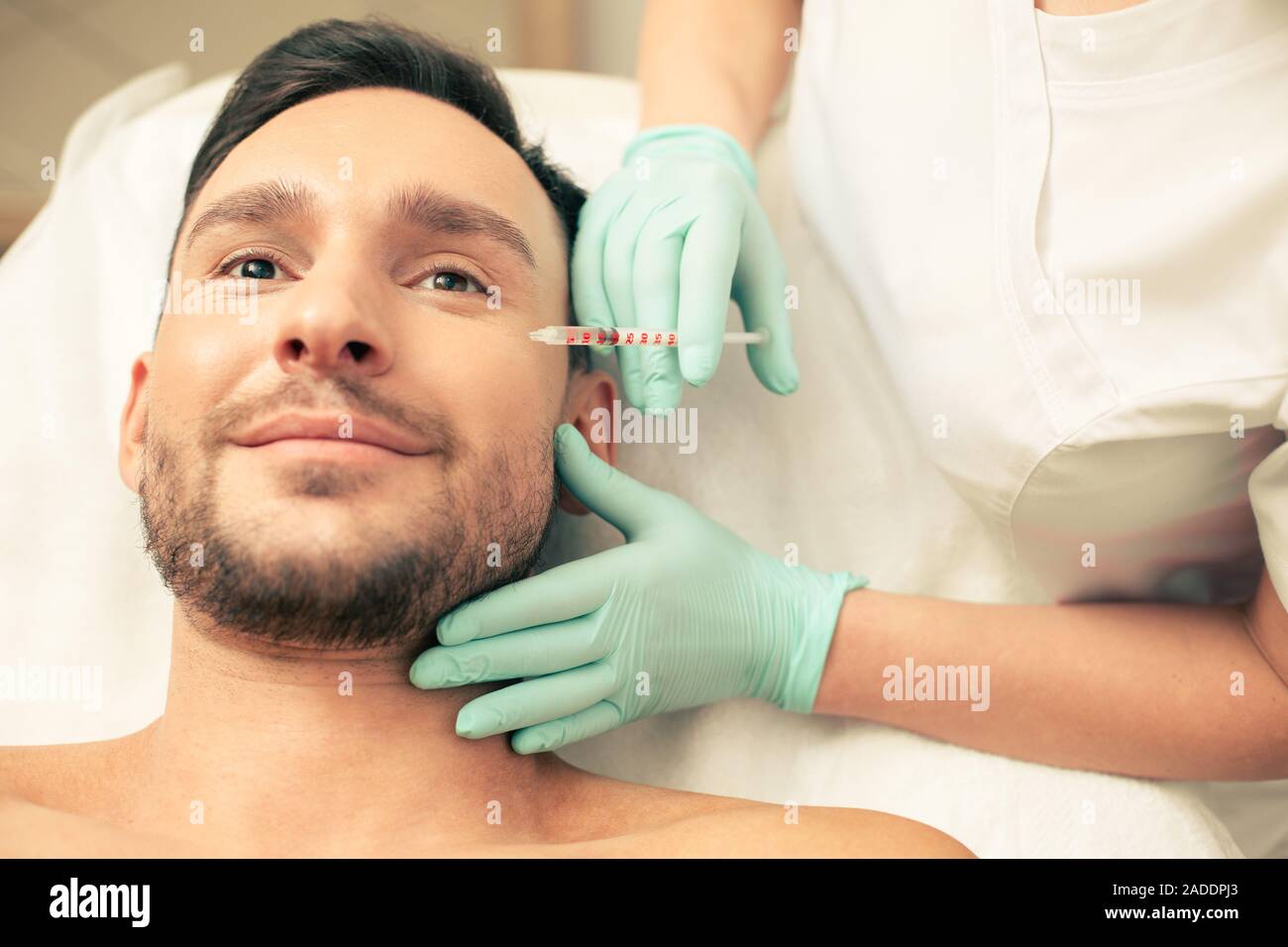 Young smiling man getting hyaluronic acid injection Stock Photo - Alamy