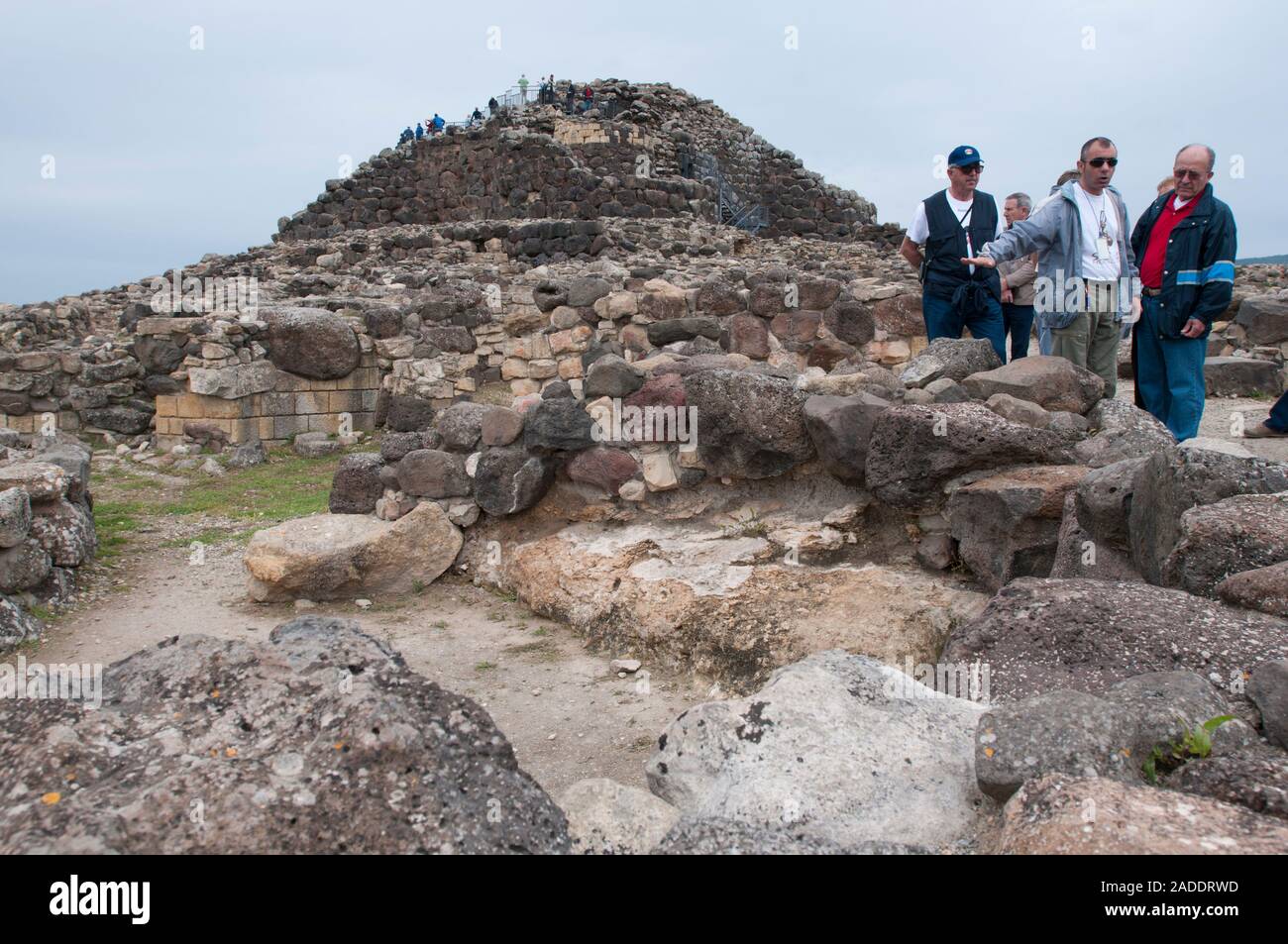 Nuraghe tourism, prehistoric Sardinia. Tourists visiting the tower and ...