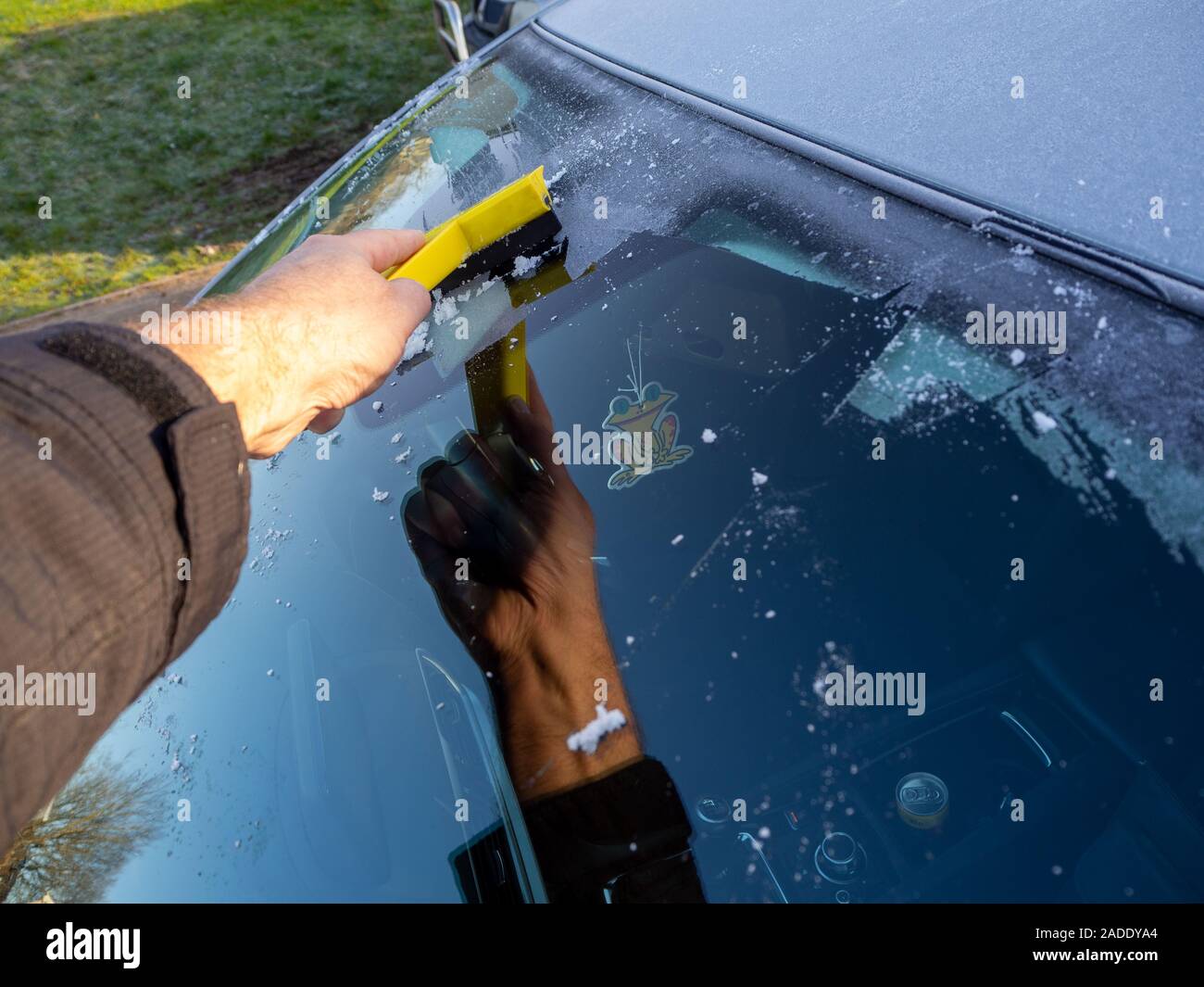 winter driving - scraping ice from a windshield taken on a cold frosty ...