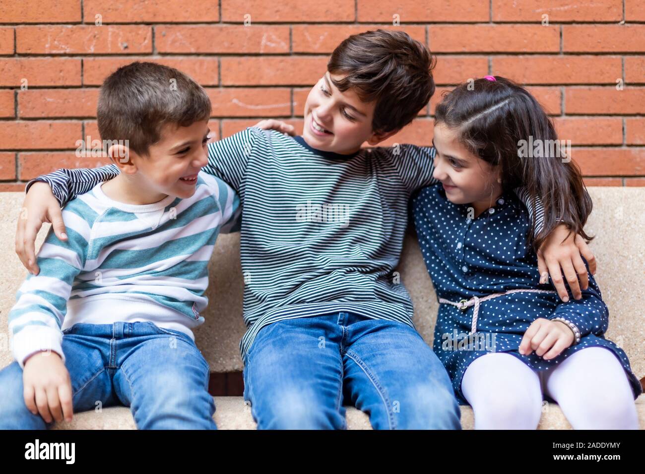 Three happy friend sitting on a bench Stock Photo - Alamy