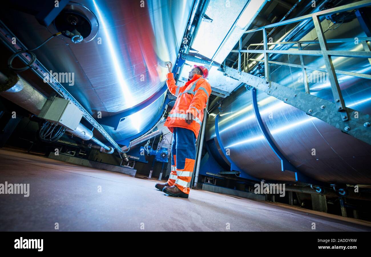 Animal rendering plant. Worker inspecting equipment at an animal ...