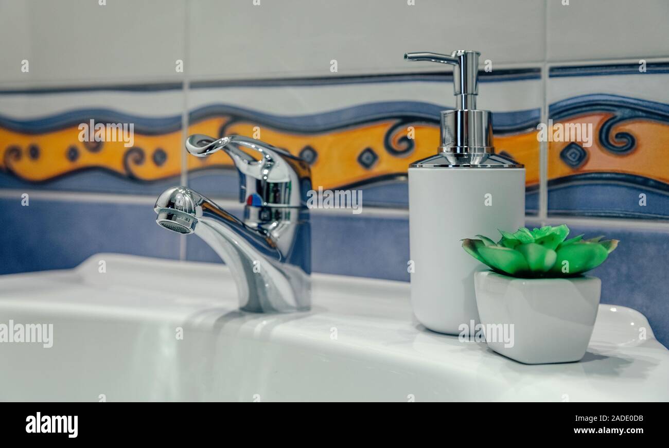Washbasin with tap, soap dispenser and plant Stock Photo - Alamy