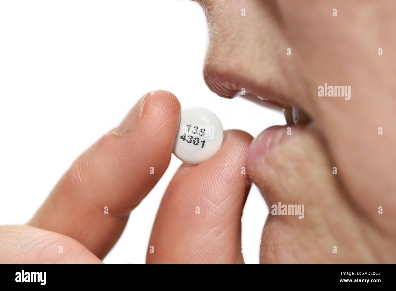 Patient taking a tablet of Mebeverine, a drug used to alleviate some of ...