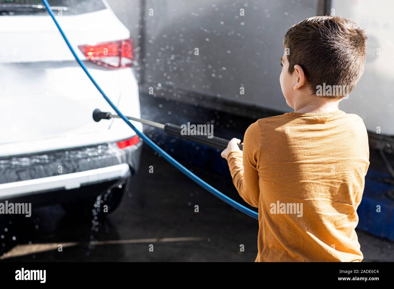 Little kid cleaning a car with a high pressure hose Stock Photo - Alamy