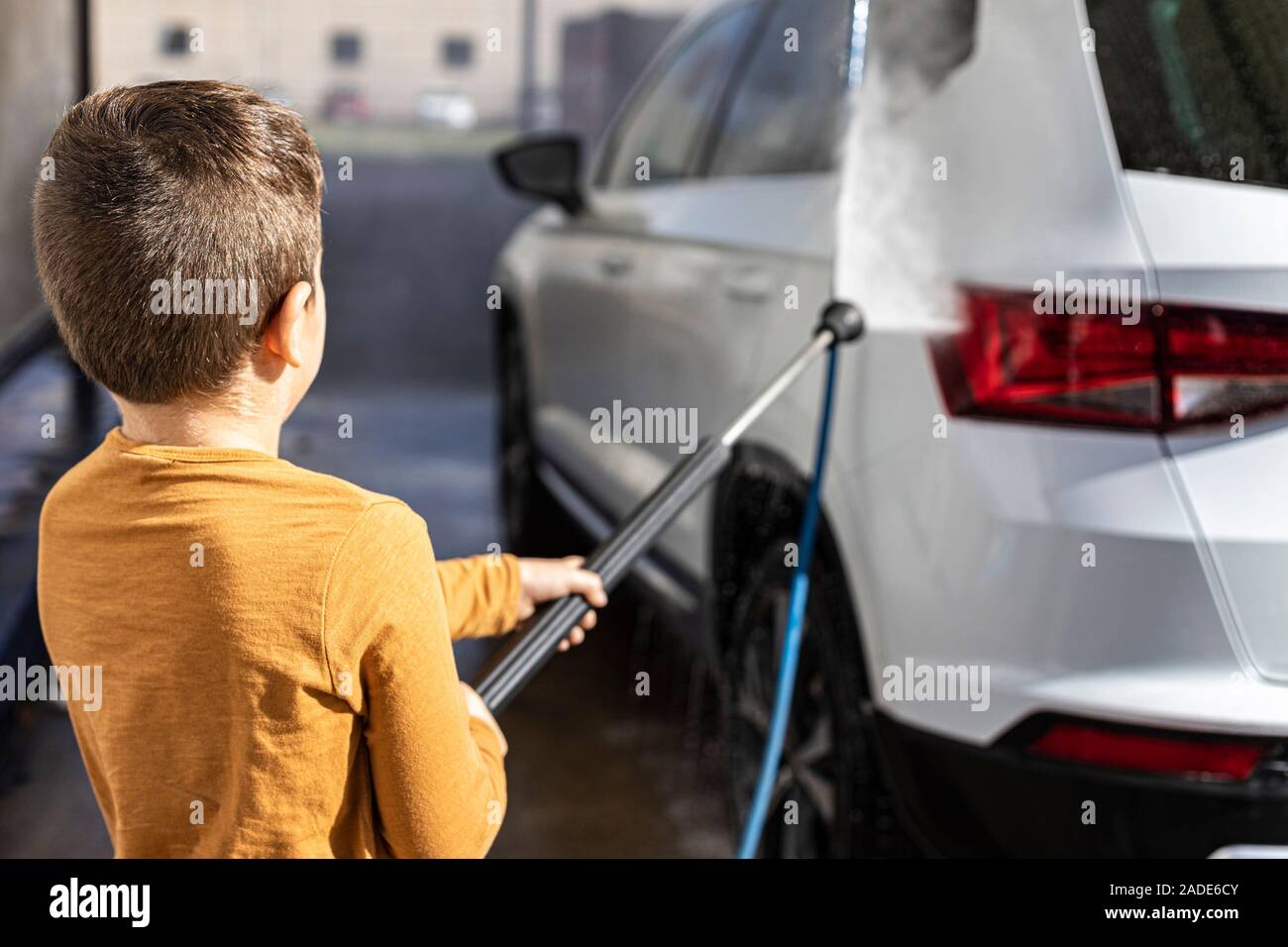 Little kid cleaning a car with a high pressure hose Stock Photo - Alamy