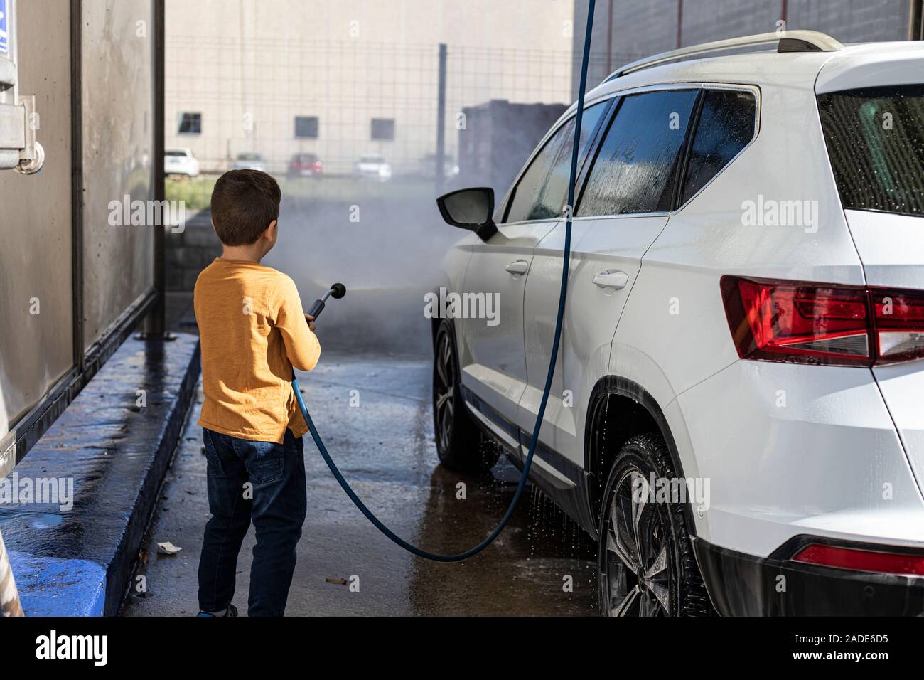 Little kid cleaning a car with a high pressure hose Stock Photo - Alamy