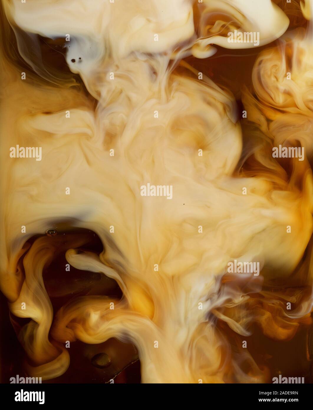 Milk mixing with coffee Stock Photo - Alamy
