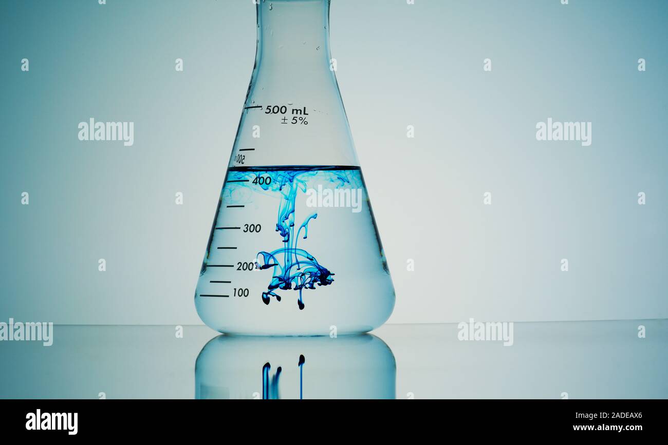 Blue liquid diffusing in flask Stock Photo - Alamy