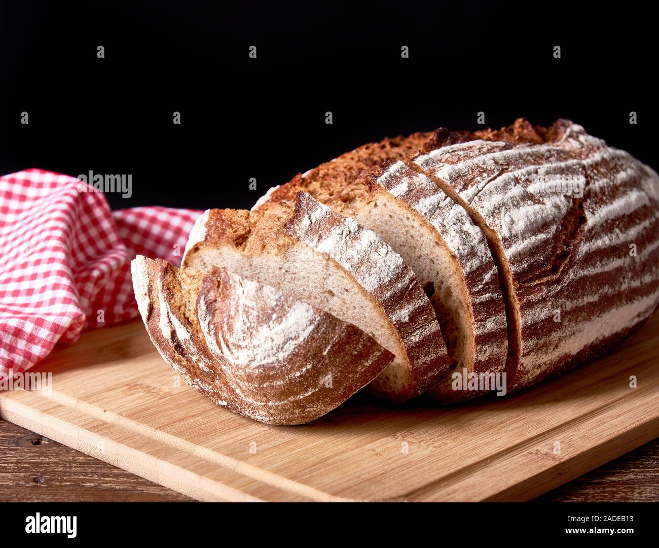 Still life with baked sliced bread loaf. Red dishcloth isolated on ...