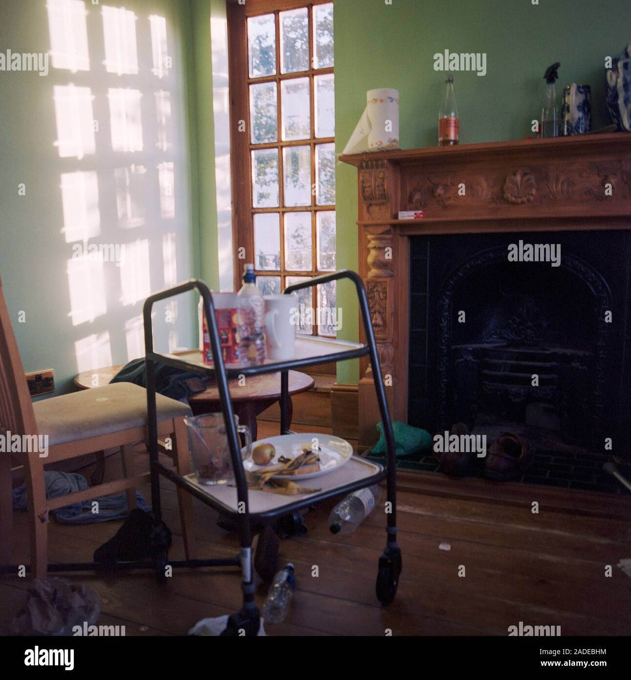 Dementia healthcare. Trolley in the living room of an elderly man with ...