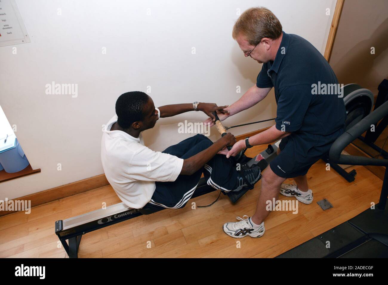 Access to services. Fitness instructor and disabled man in the gym ...