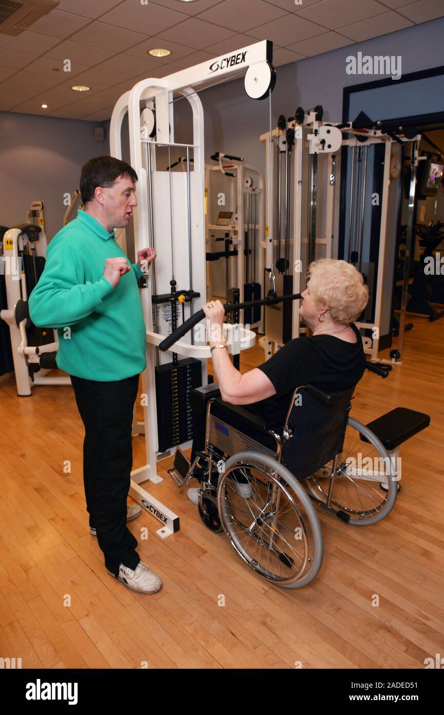 Instructor showing woman how to use weights at an inclusive fitness gym ...